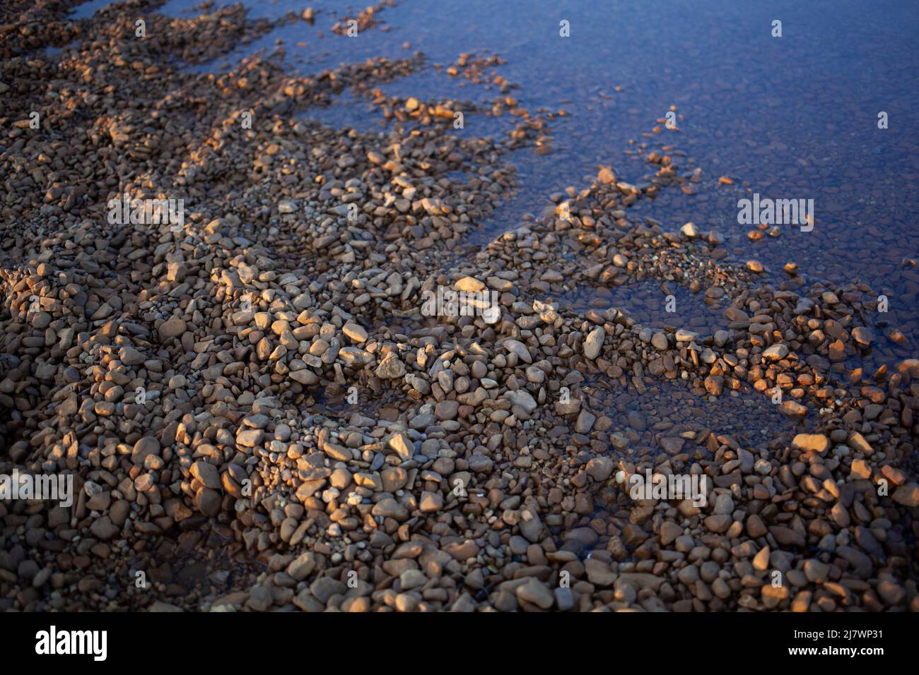 Rocks and pebbles by the water Stock Photo - Alamy