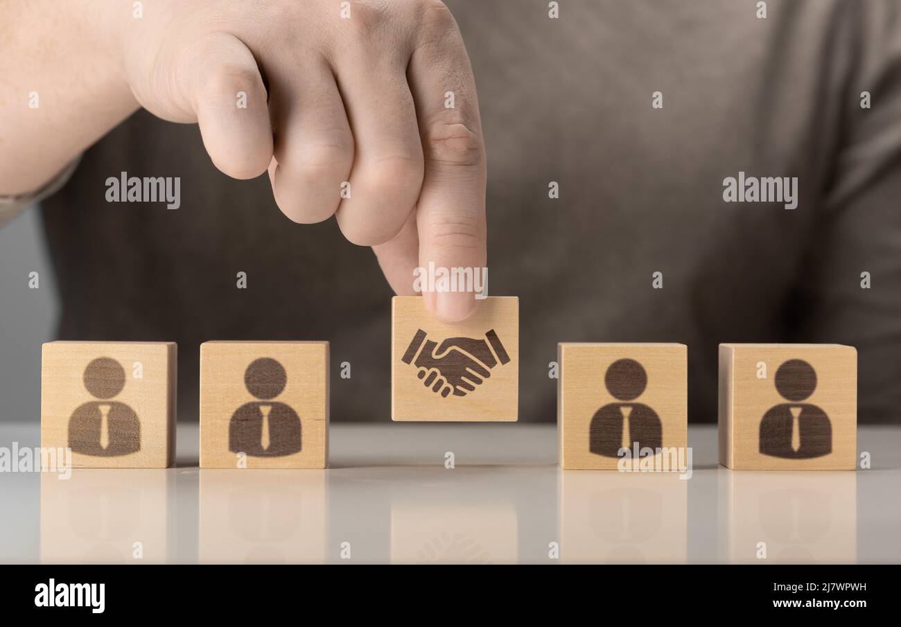 business contract. Hand putting hand shaking on wooden cube block in ...