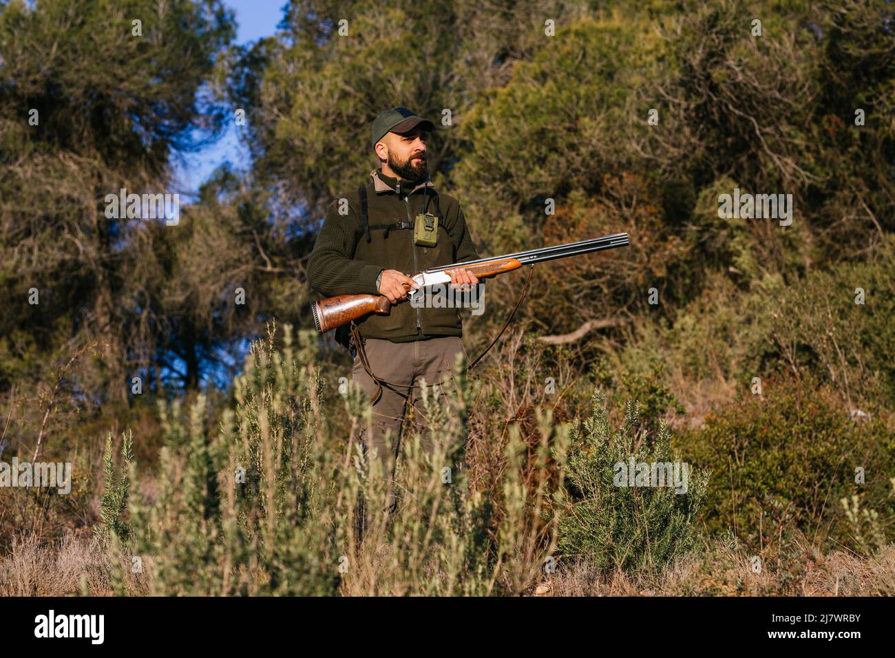 Adult man holding his gun in middle of nature looking away Stock Photo ...