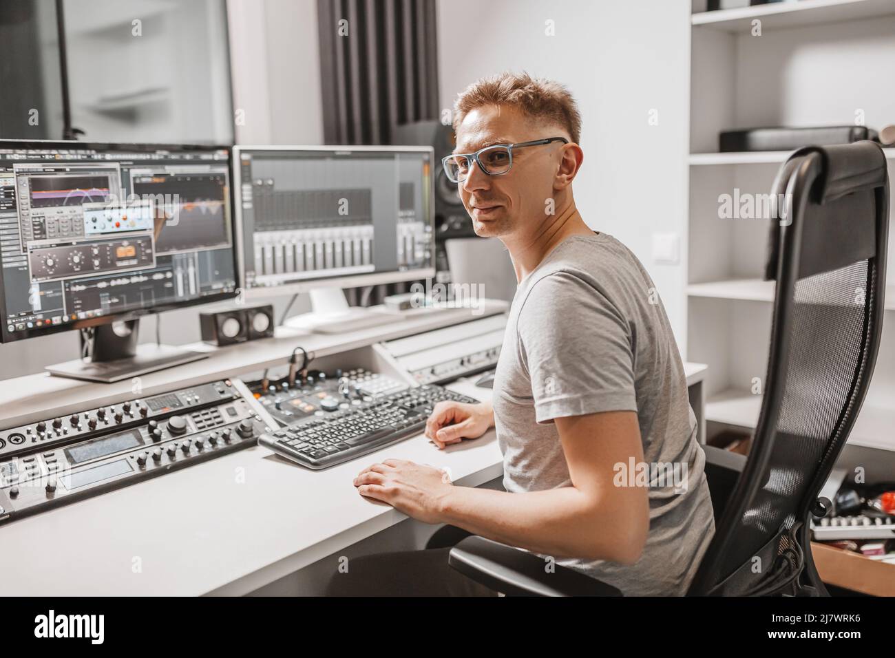 Man working in music studio using computer wearing glasses. Sound ...