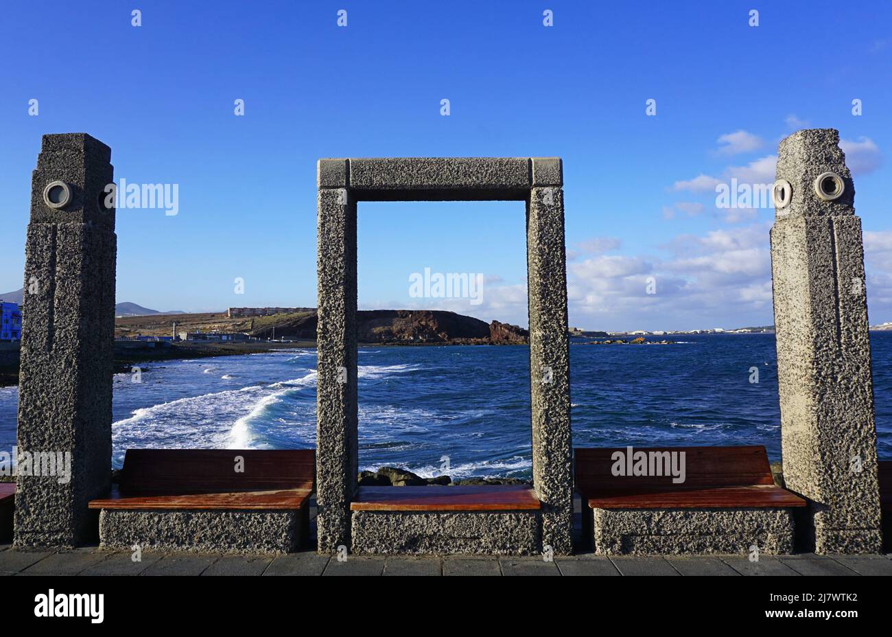Old stone columns and gate on the pier with agitated sea and waves in ...