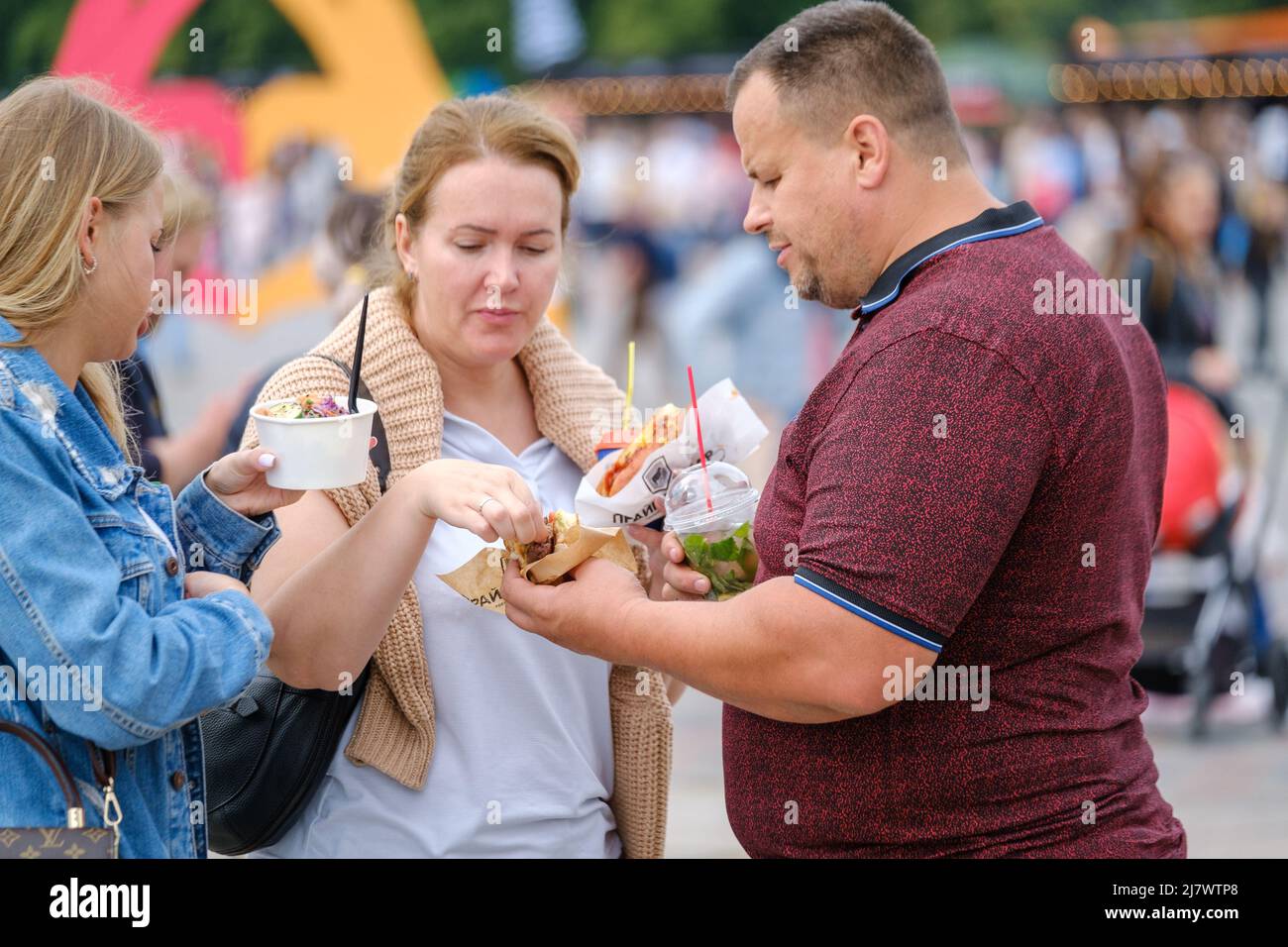 People eating street food during event Stock Photo - Alamy