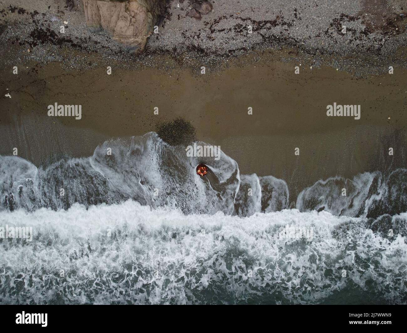 Aerial view from above on old rusty floating marine mine on the beach ...