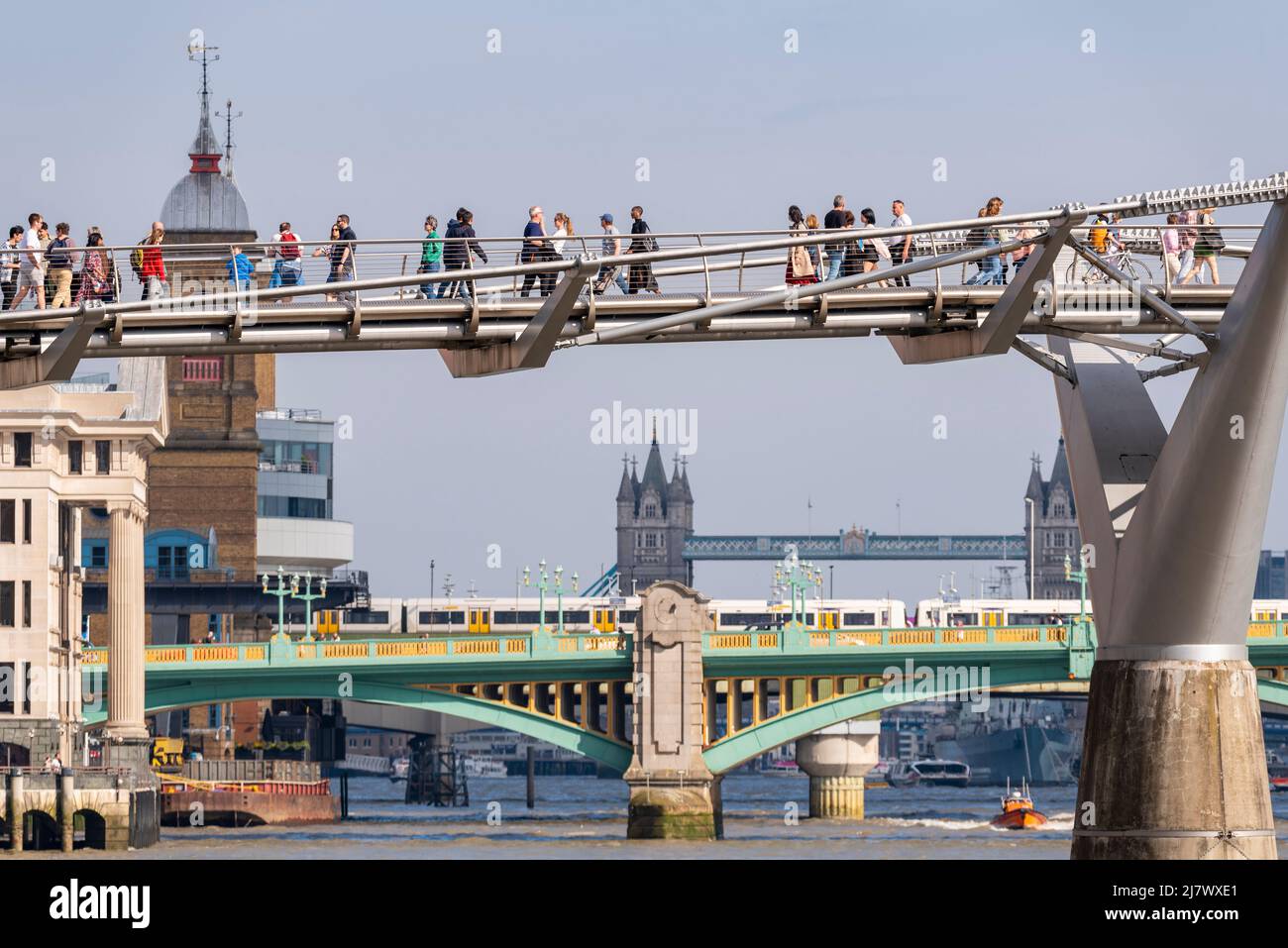 People walking across the Millennium Bridge in London, UK, over ...