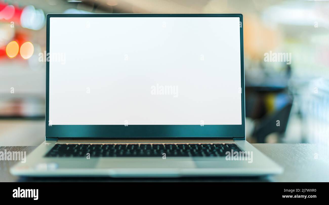 A laptop computer with an empty screen in an open space office Stock ...