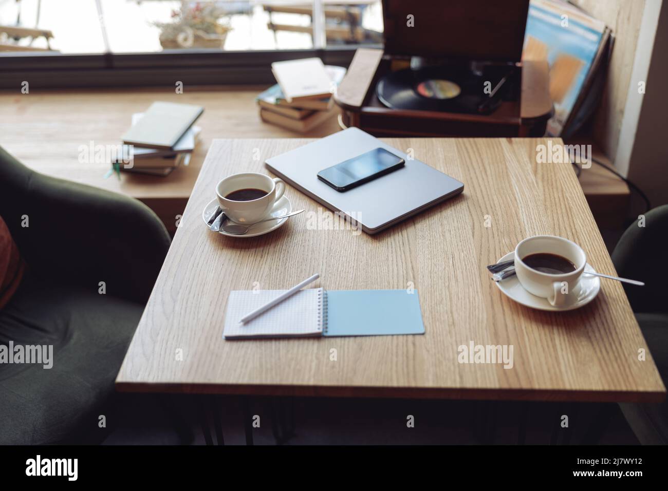Wooden table with two cups of coffee and business stuff. Cozy place for ...