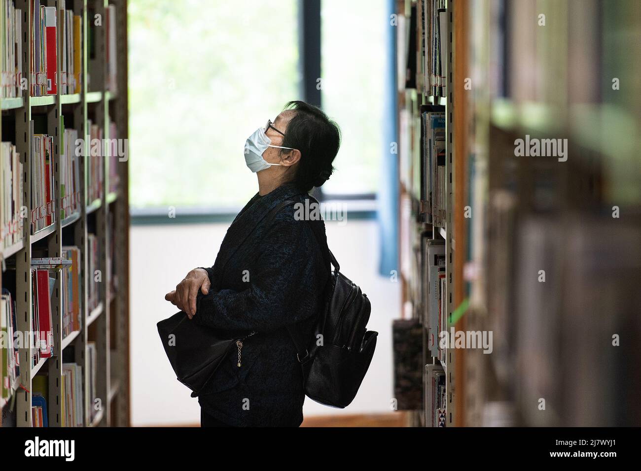 Wuhan, China. 11th May, 2022. A woman wearing a face mask selects books ...