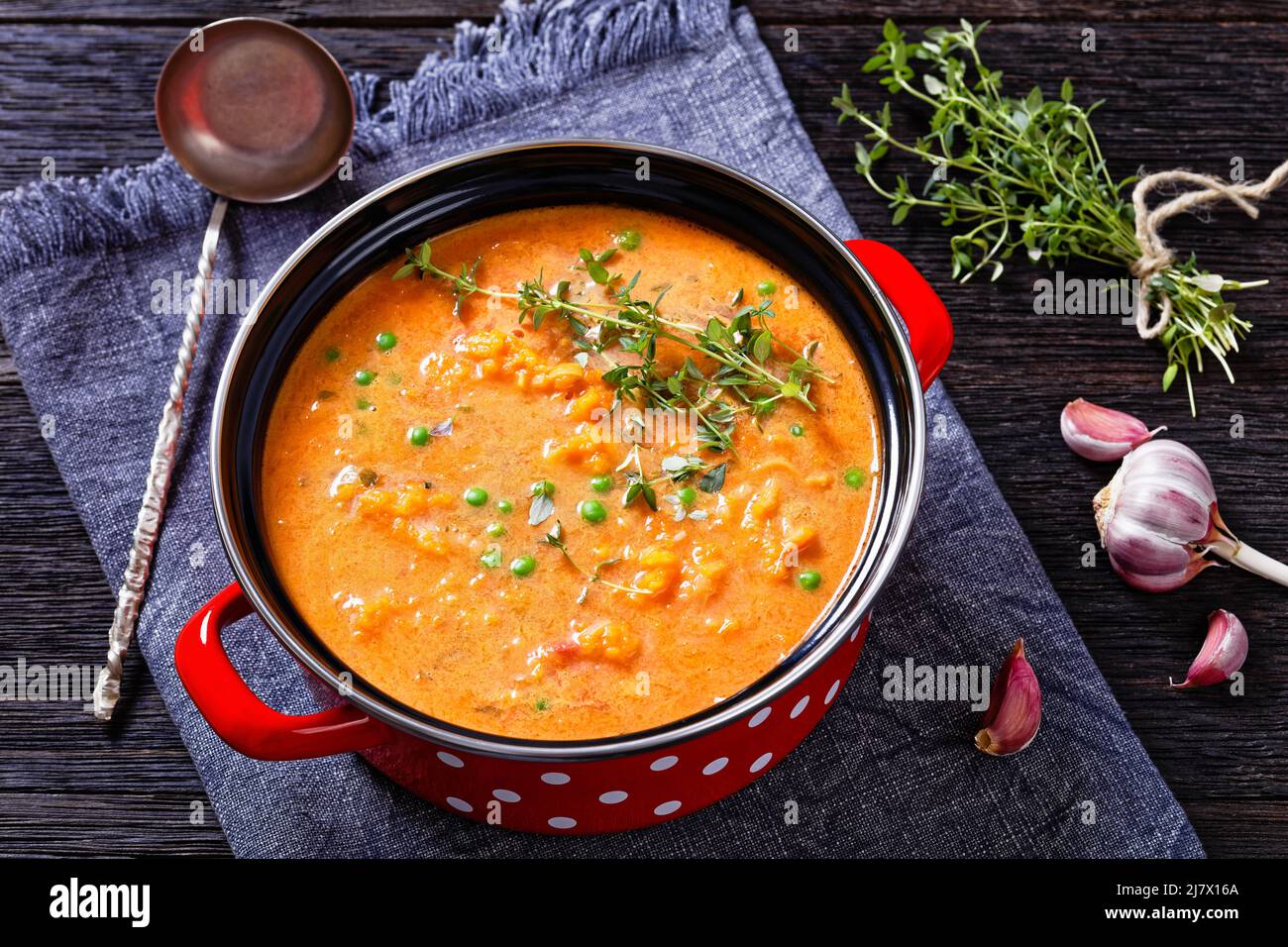 roasted yams thick soup loaded with vegetables in red pot on dark wood ...