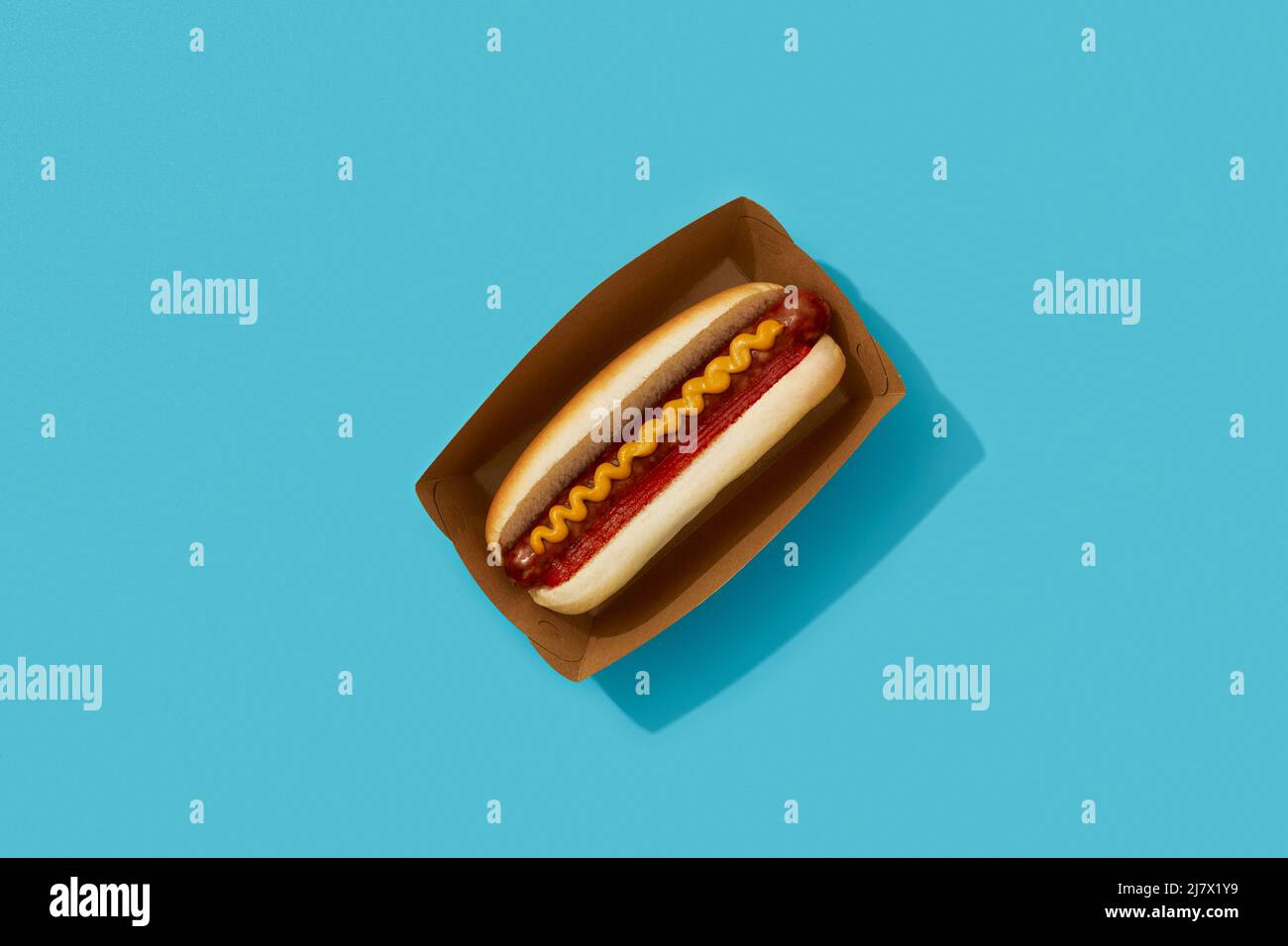 Classic hot dog with wurst, ketchup and mustard on blue background ...