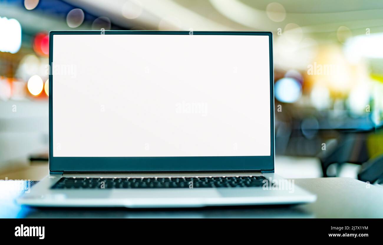 A laptop computer with an empty screen in an open space office Stock ...