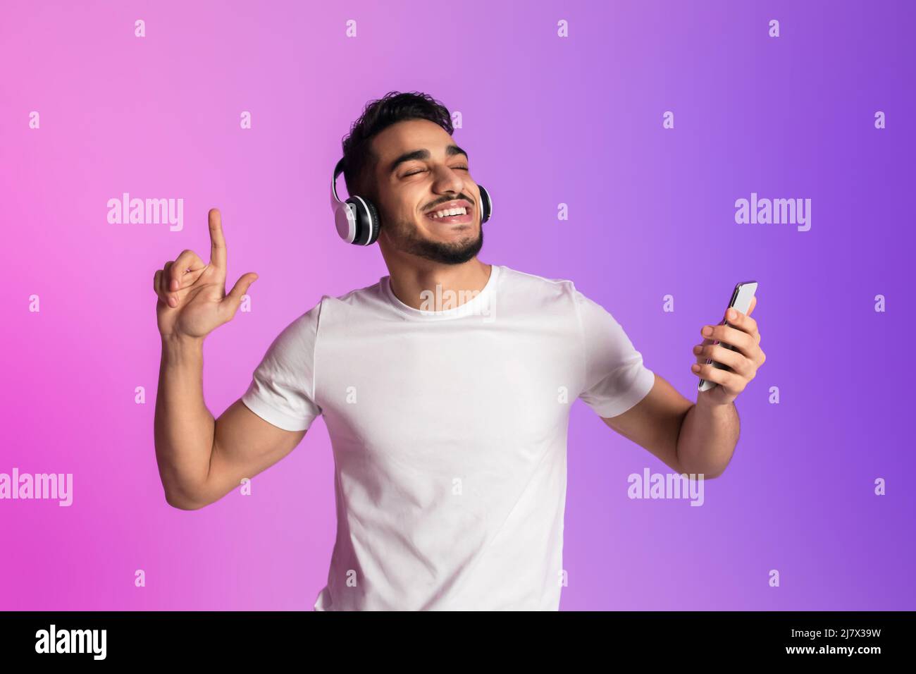 Handsome Young Arab Man Listening To Music In Headphones Using New