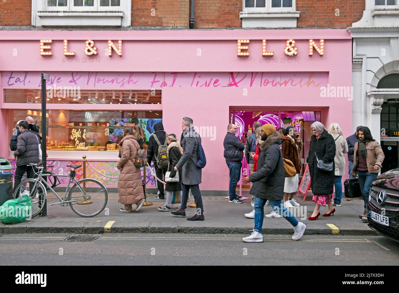 People pedestrians walking outside EL&N Eat, Live & Nourish pink cafe ...