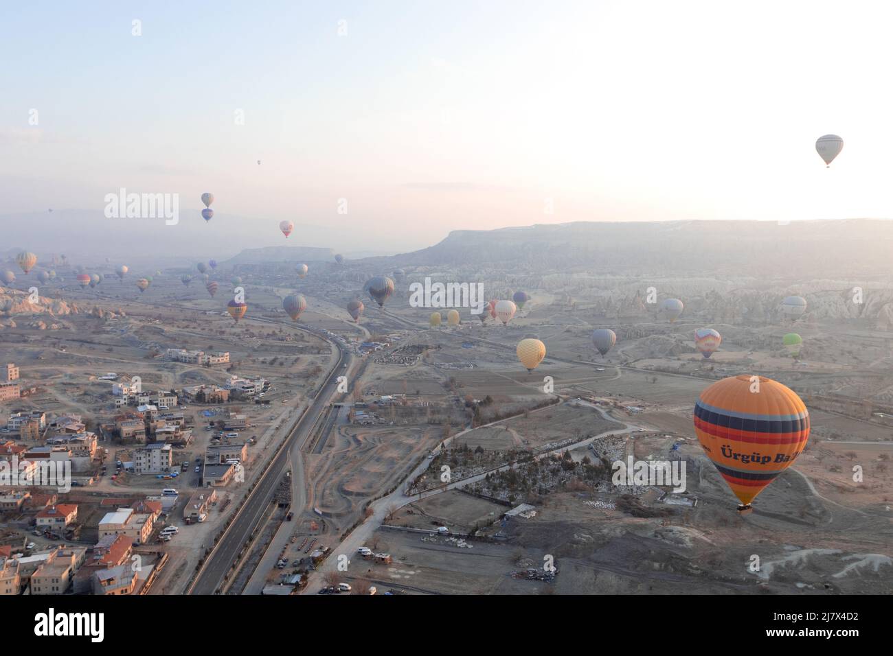 Hot air balloons are flying over the mountainous terrain. Aerial ...