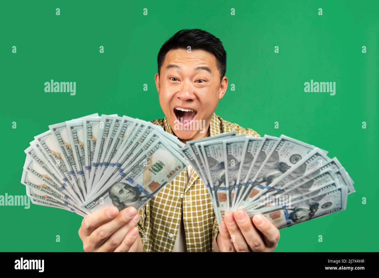 Overjoyed rich mature asian man holding two fans of money, celebrating ...