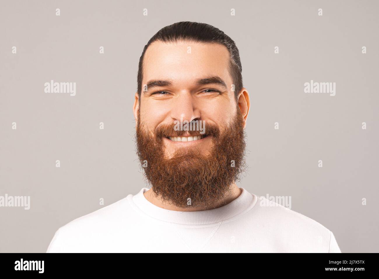 Close up portrait of a young smiling bearded man looking at the camera ...