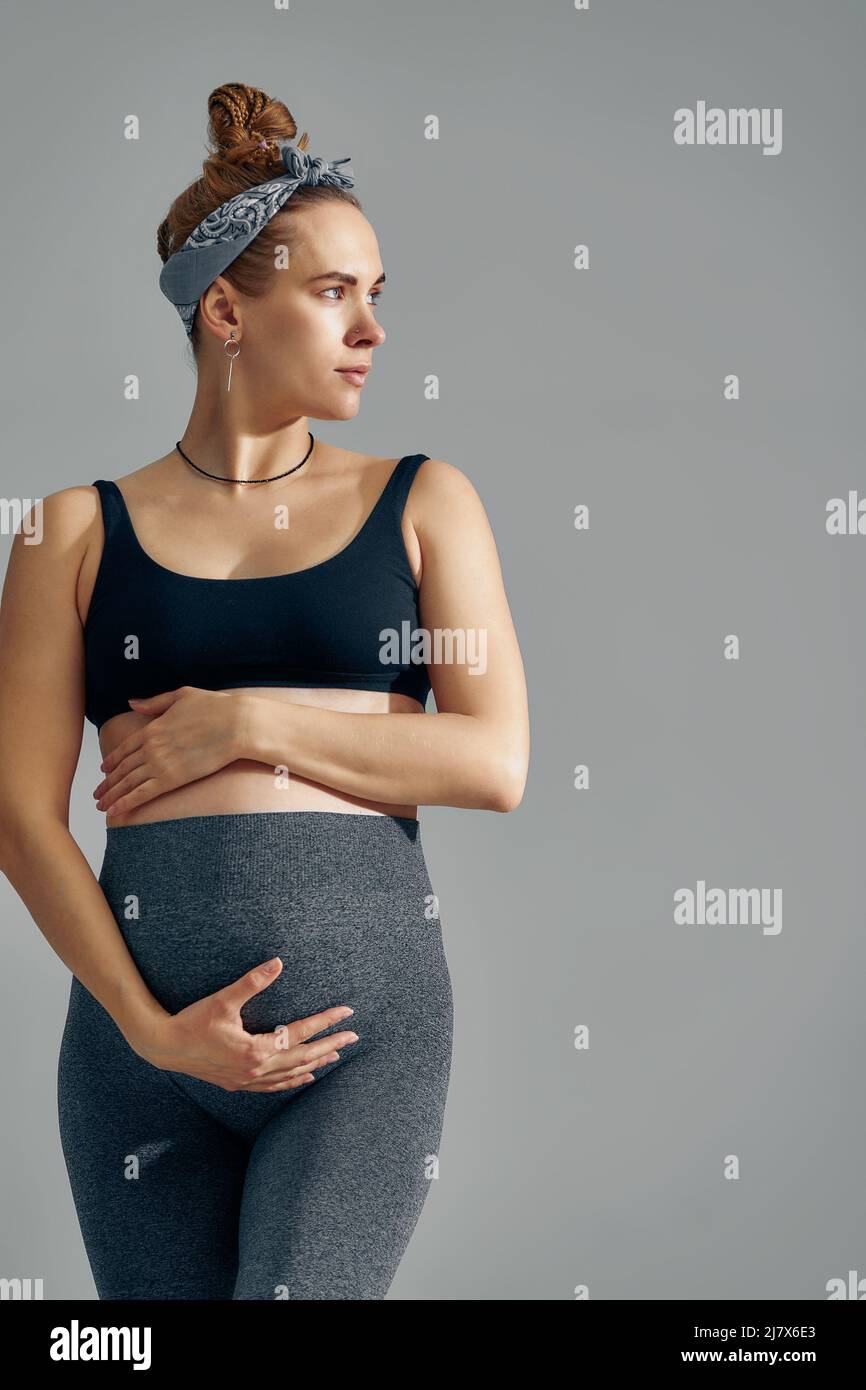 Cute Pregnant Belly Isolated On Gray Side View Of Young Pregnant Woman Embracing Her Abdomen
