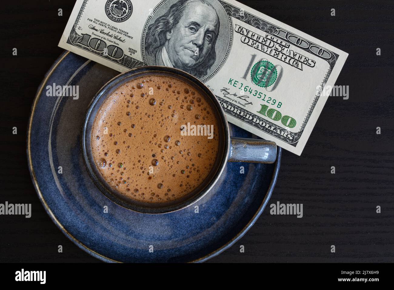 cup of coffee on 100 dollar banknotes background for design purpose ...