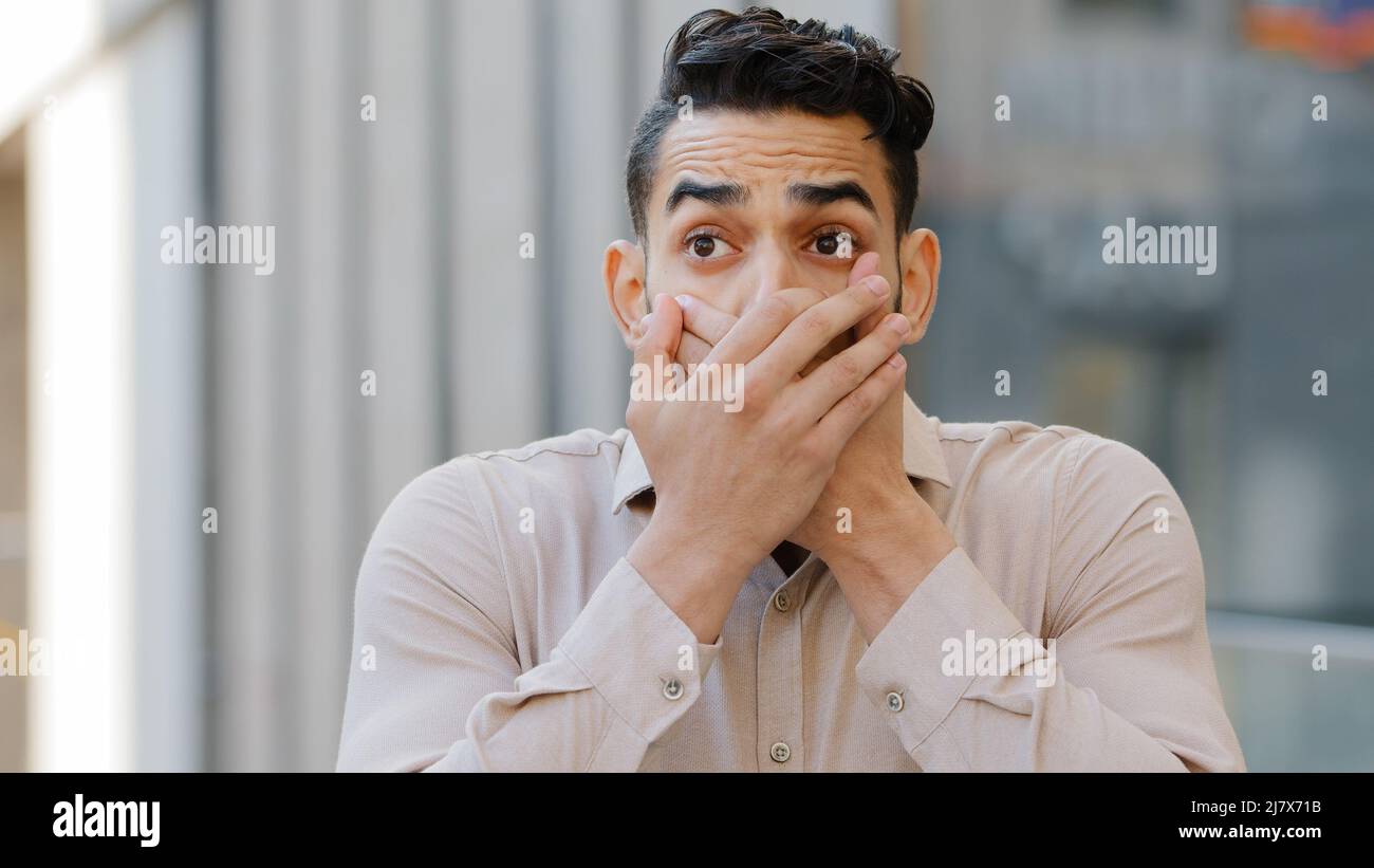 Hispanic man scared businessman boss stands in city covering mouth with ...