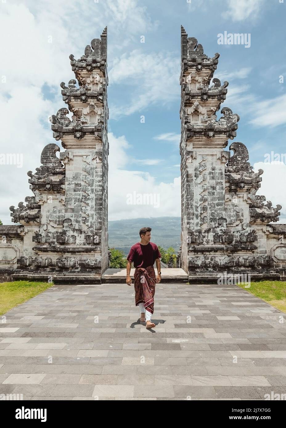 young male tourist wearing a traditional balinese sarong walking in ...