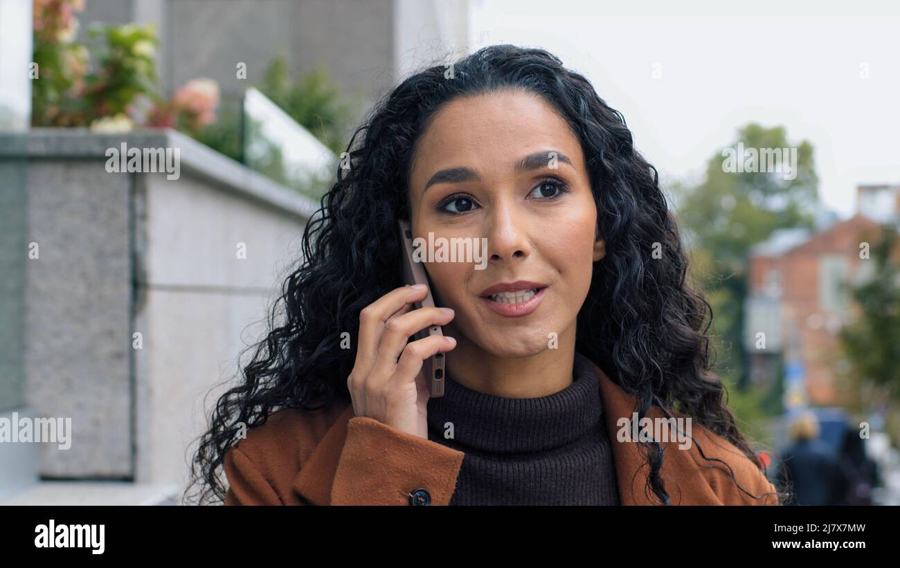 Close-up woman talking cell mobile phone in city. Portrait young girl ...
