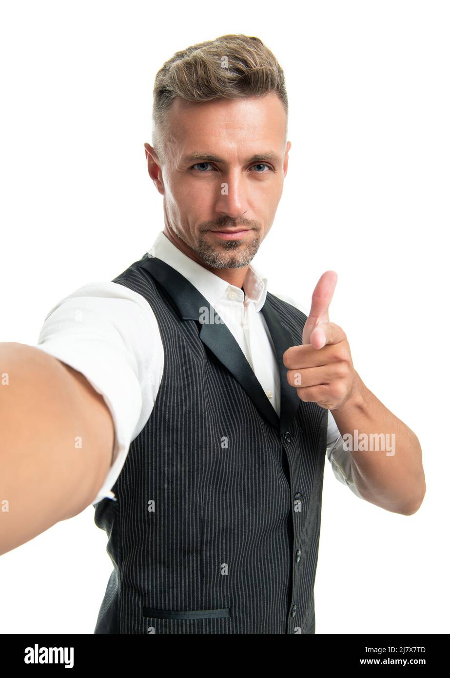 Serious manager in suit vest taking selfie pointing finger gun hand ...