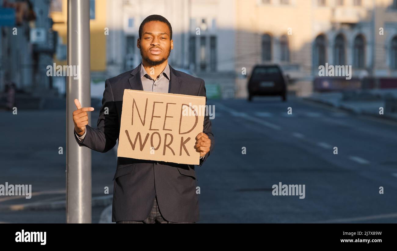Mixed Race businessman holding sign Need Work points index finger ...