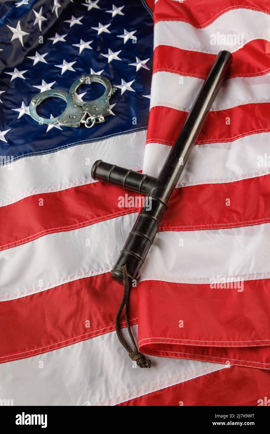 silver metal handcuffs and black rubber police baton over full-frame ...