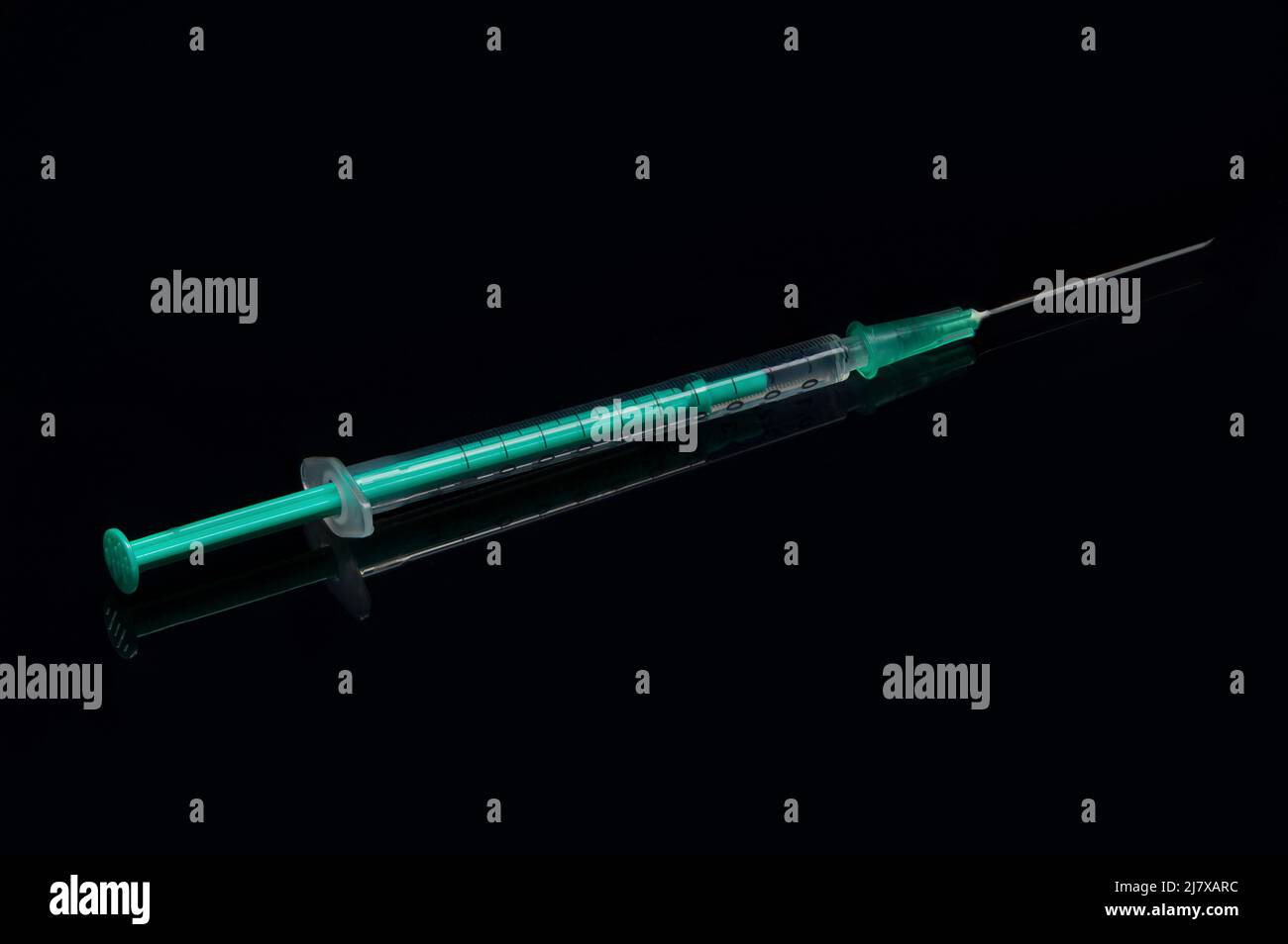 close-up of a syringe pulled up with a vaccination serum on a black ...