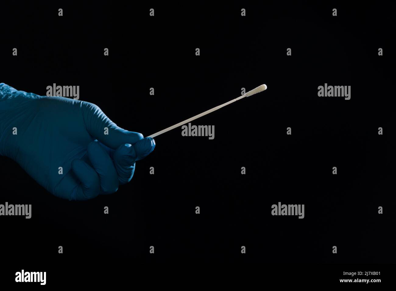 Close-up of doctor's hand handling a smear test or swab test in front ...