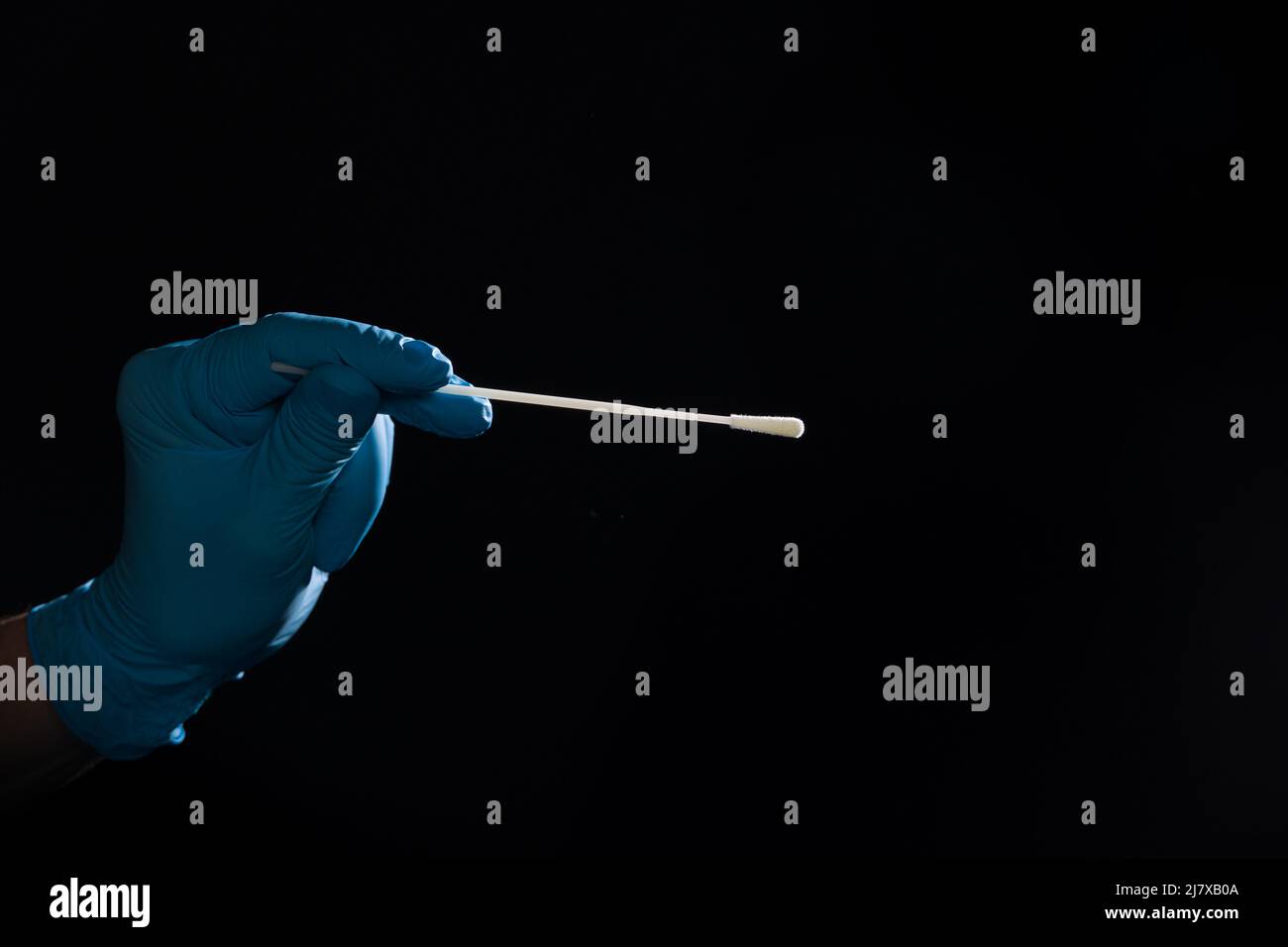 Close-up of doctor's hand handling a smear test or swab test in front ...