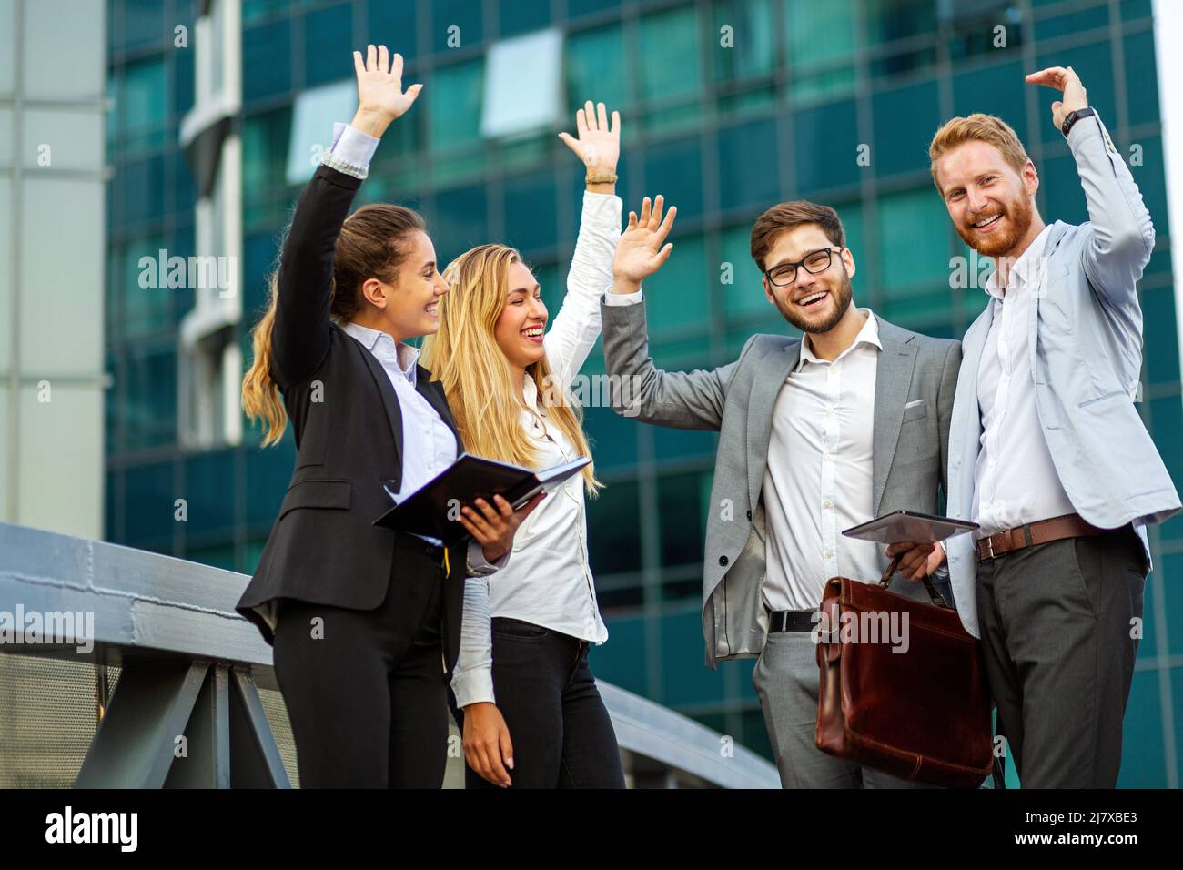 Group of happy successful business people holding their arms up and ...