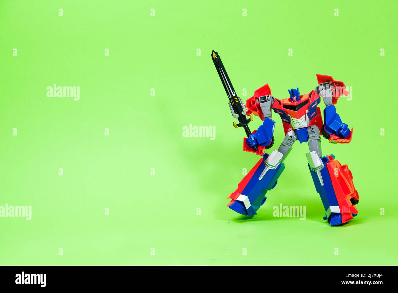 Robot transformer red and blue on green background with space for text ...