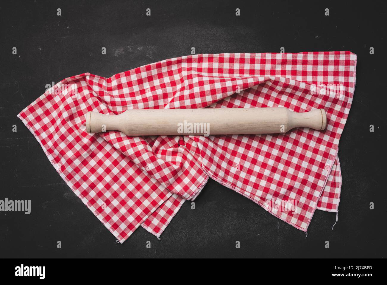 Old wooden rolling pin for rolling dough on a black background, top ...