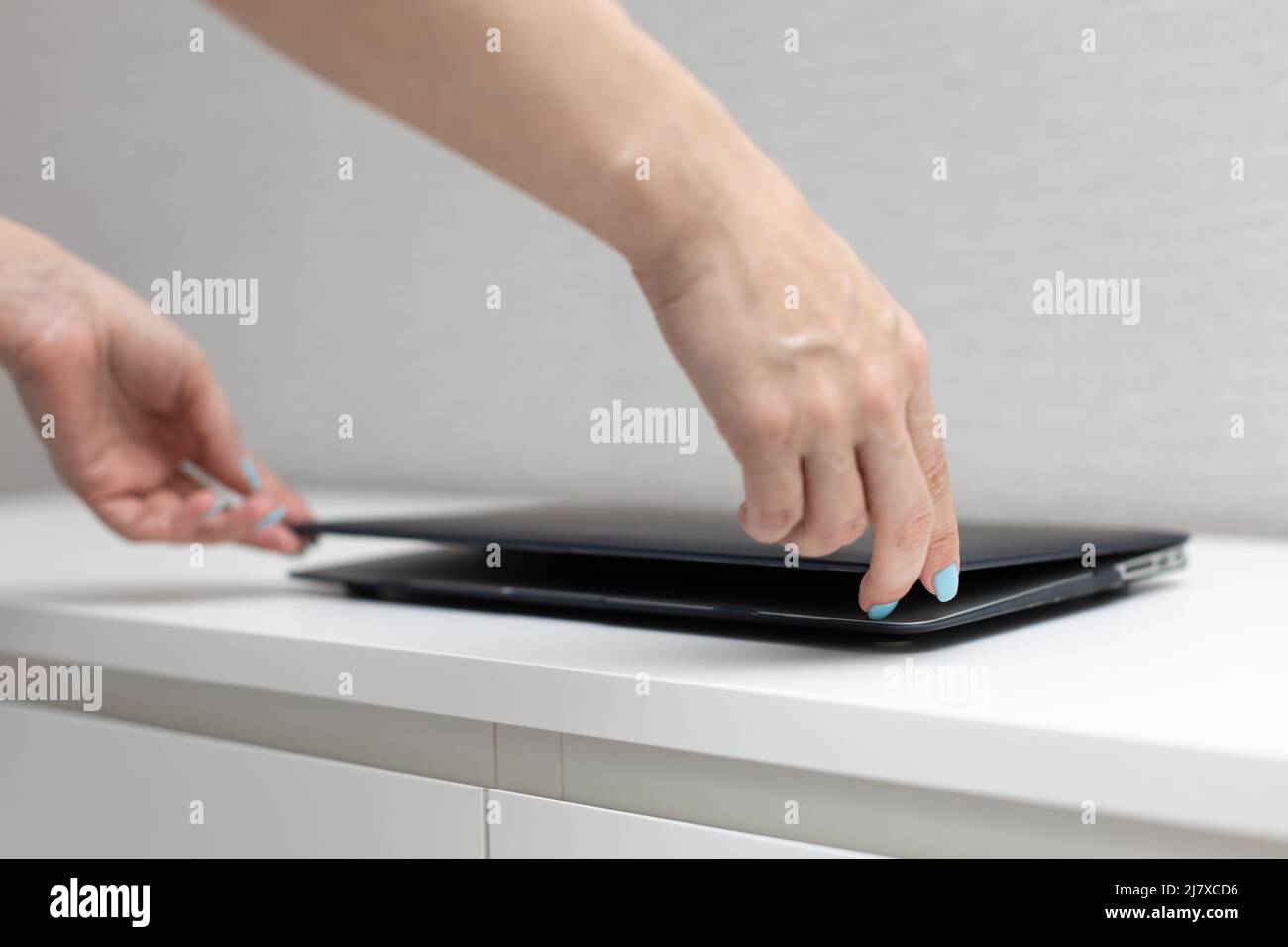 female hand opens the lid of a laptop on a white background. High ...