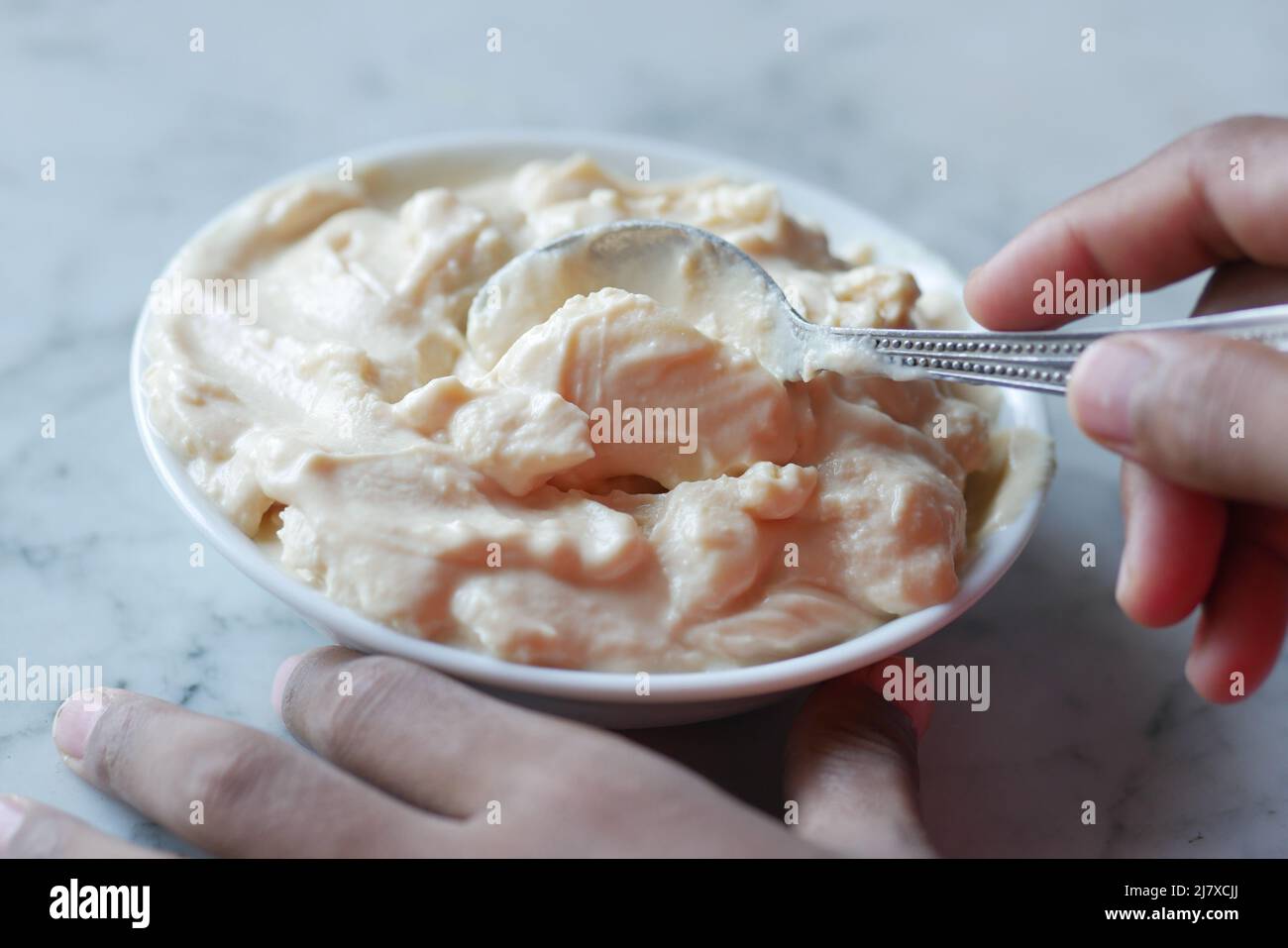 Top view of man's hand eating fresh yogurt from a bowl Stock Photo - Alamy