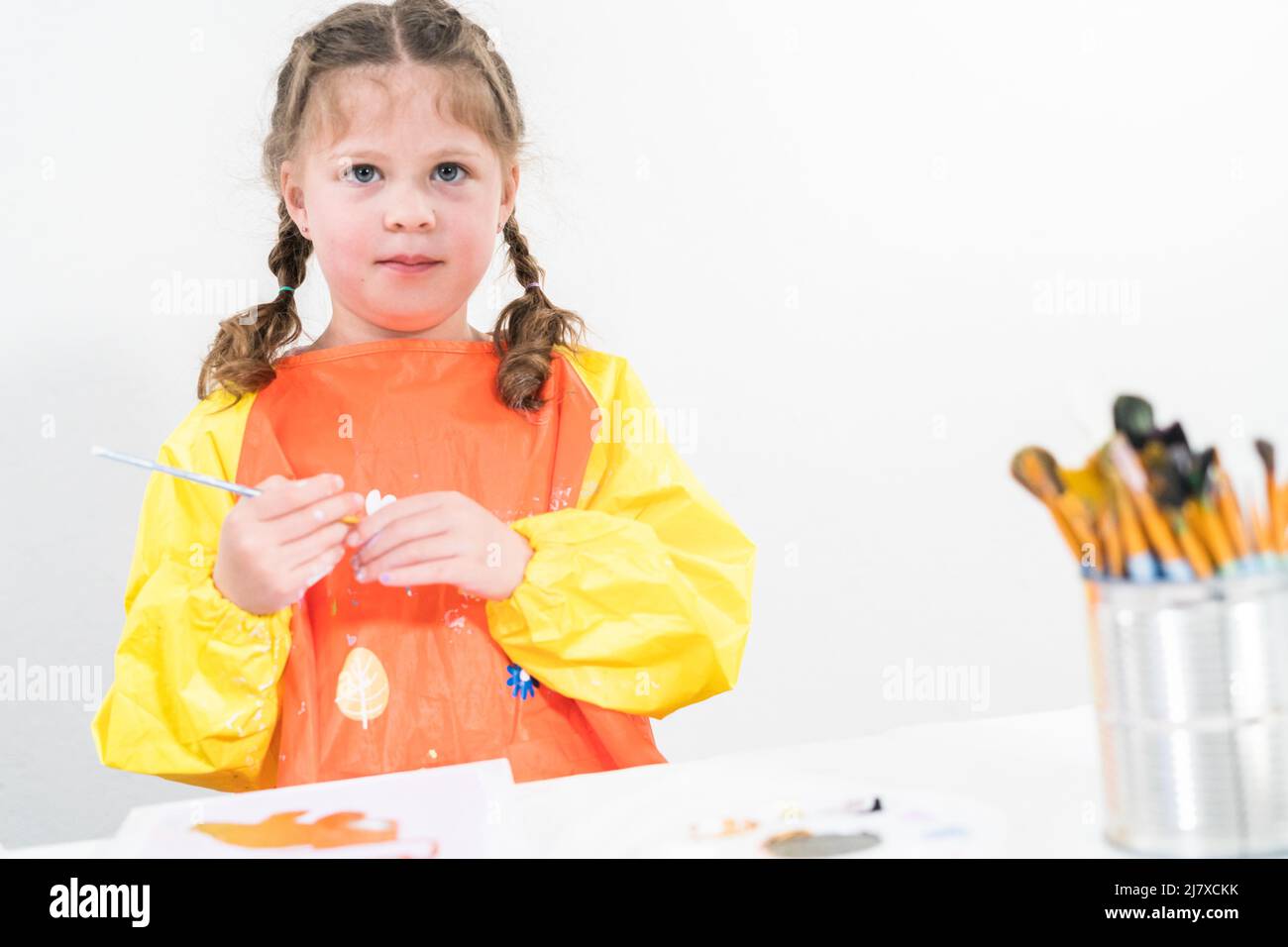 Little girl working on an art project with acrylic paint at homeschool ...