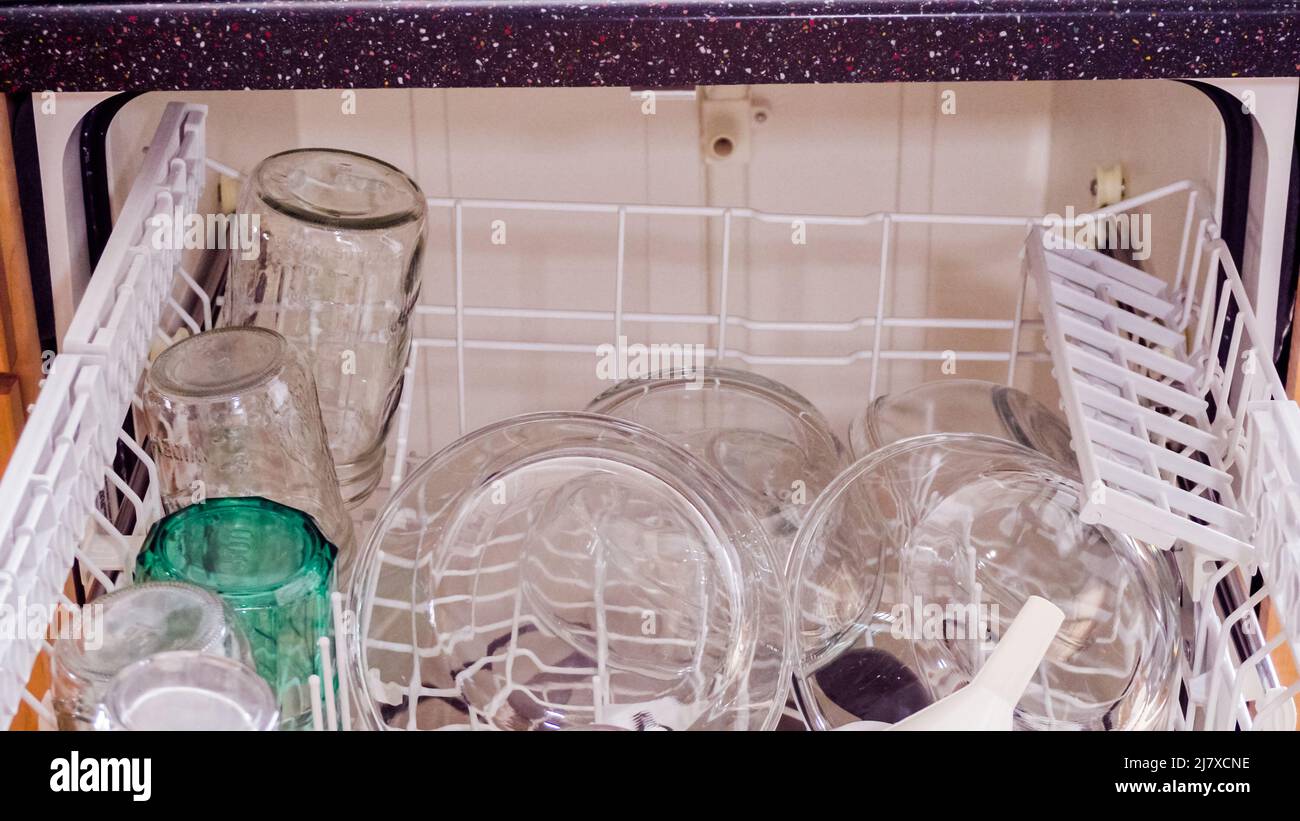Washing dishes in the dishwasher in a residential kitchen Stock Photo ...