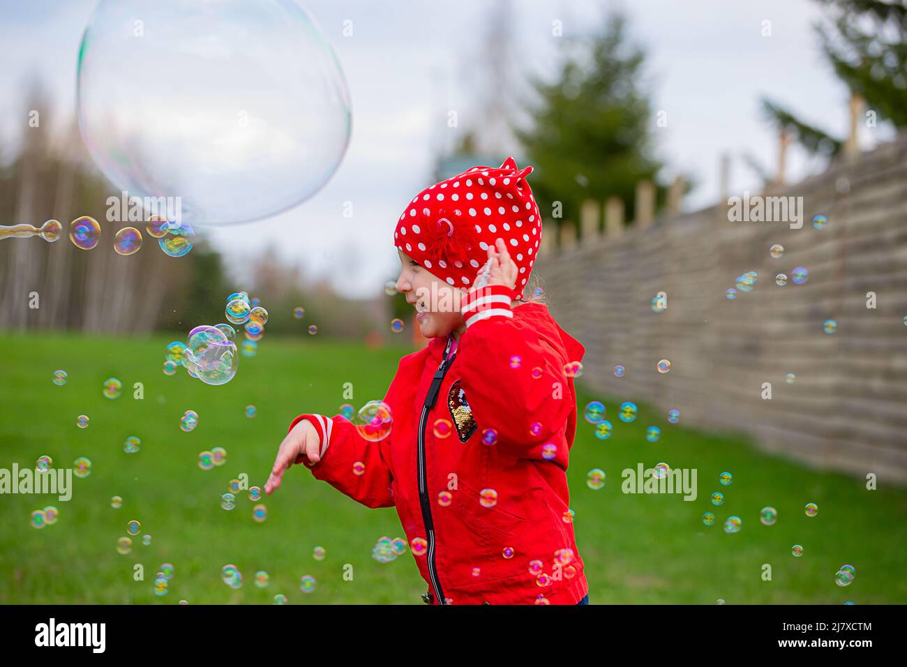 Little smiling girl playing with soap bubbles Stock Photo - Alamy