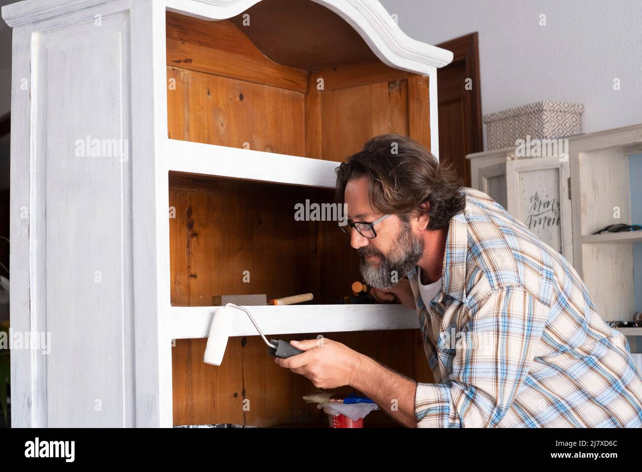 Mature man at home working on old renewed furniture. Concept of ...