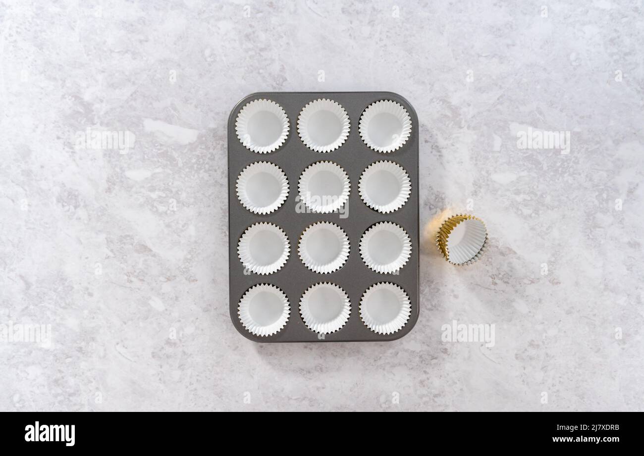 Flat lay. Lining cupcake pan with foil cupcake liners to bake s'mores ...
