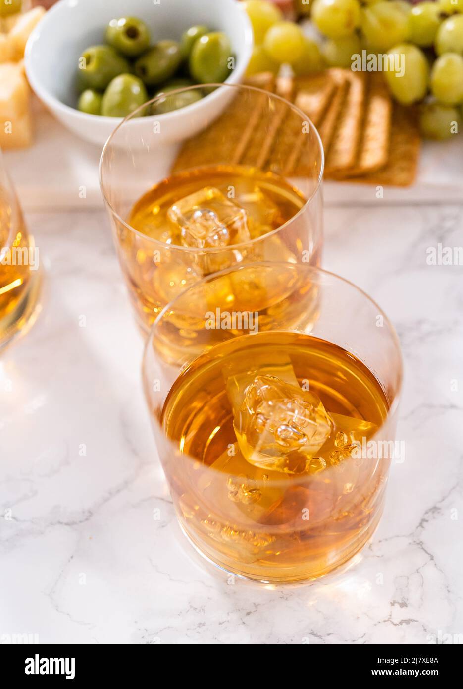 Scotch on the rocks in whiskey glass on a white marble surface Stock ...