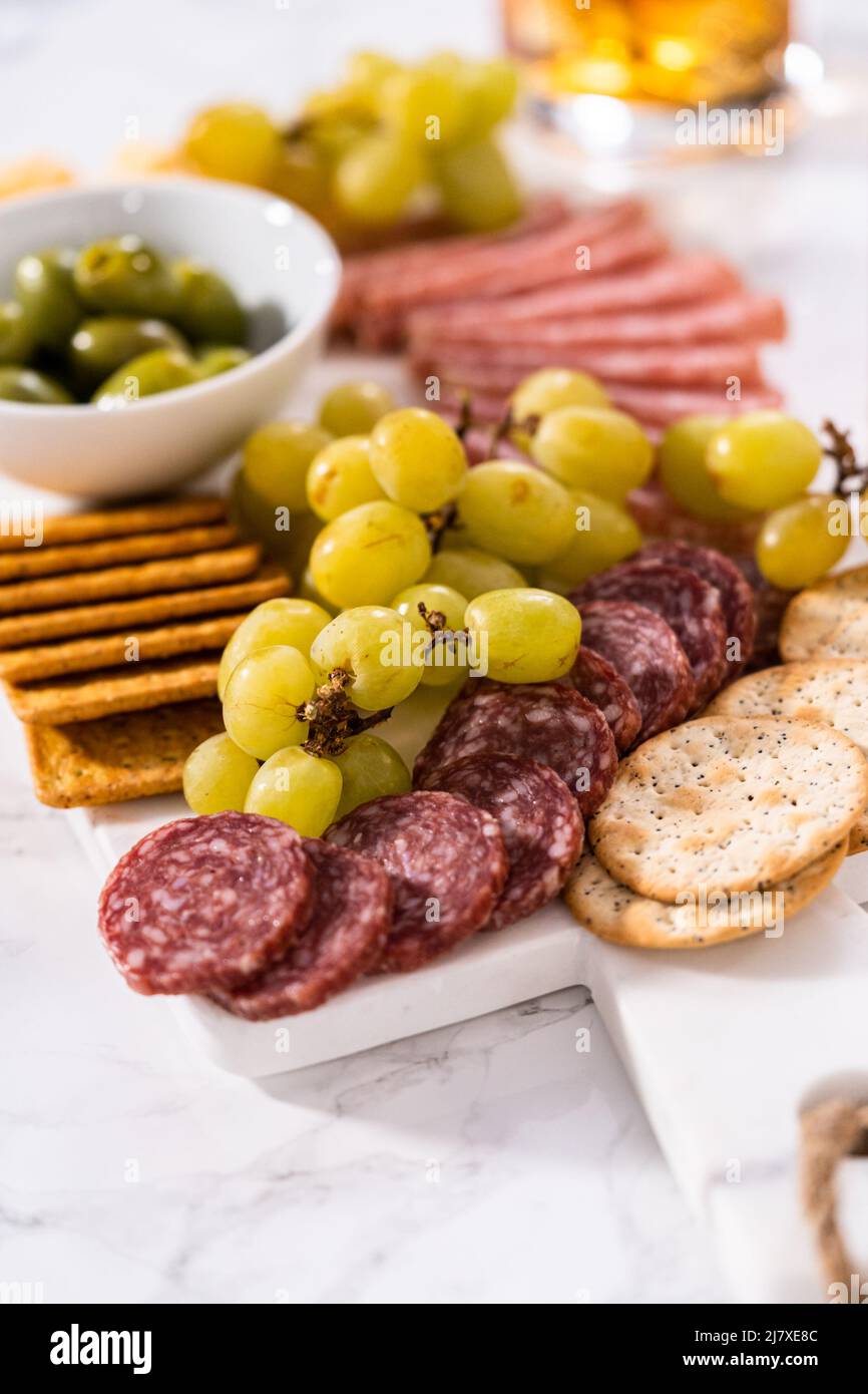 Cheese, meat, and crackers appetizer board on a marble surface Stock ...