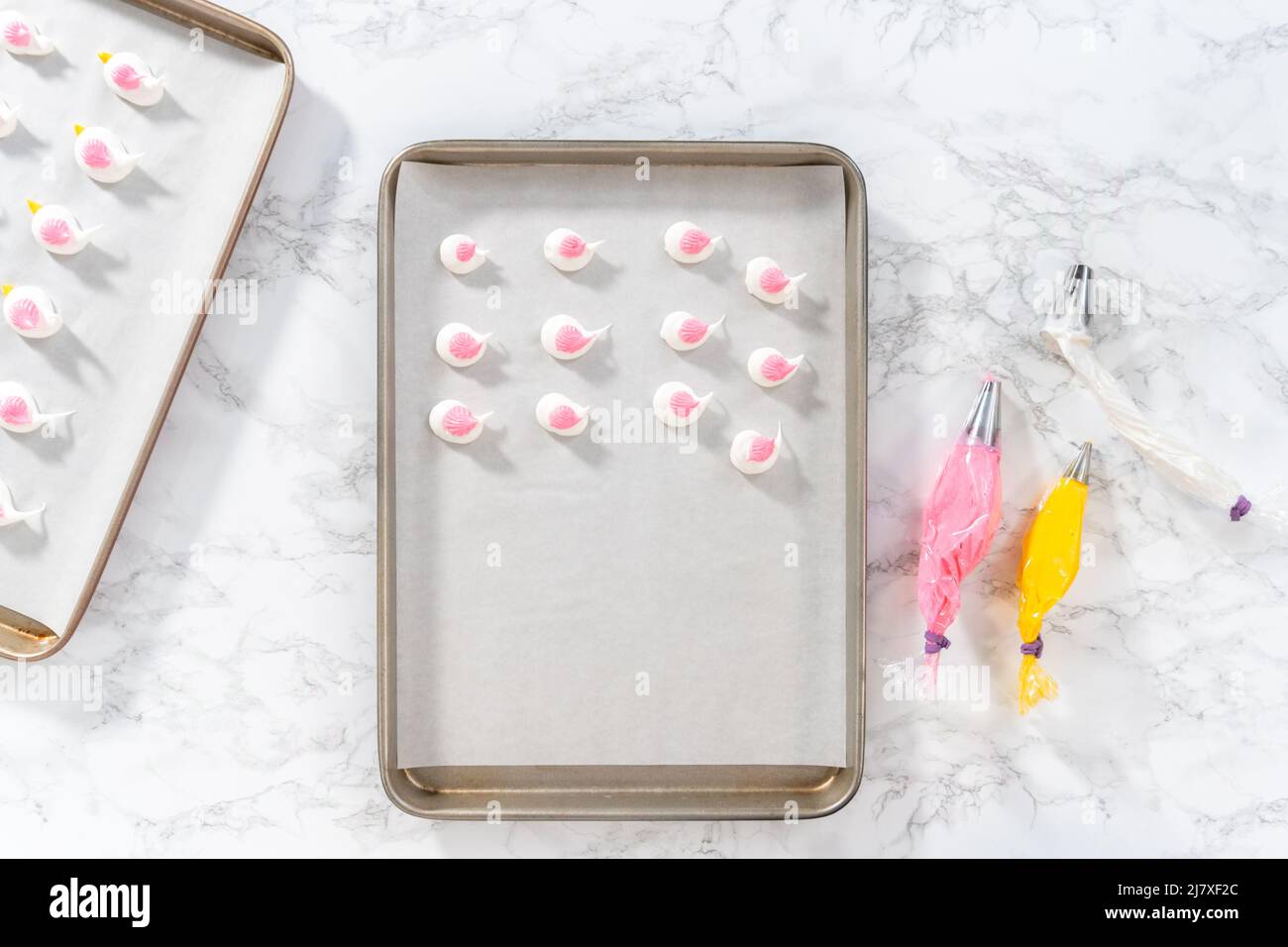 Piping meringue with piping bags into the baking sheet lined with ...