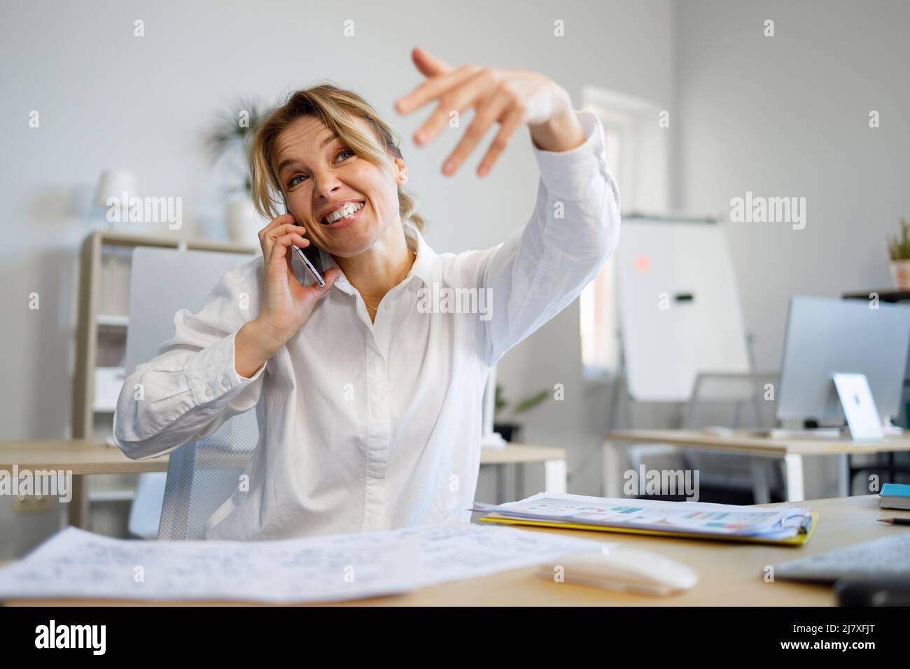 Busy business woman talking on the phone and asking her employee to ...