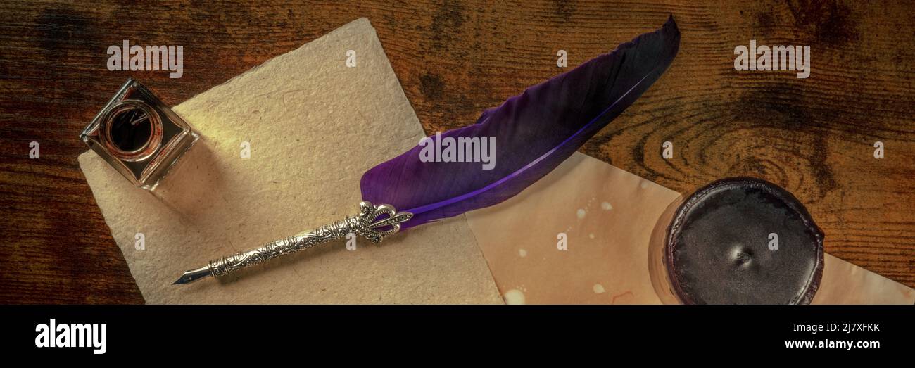 Feather quill pen with a vintage inkwell, old paper, and a black candle ...