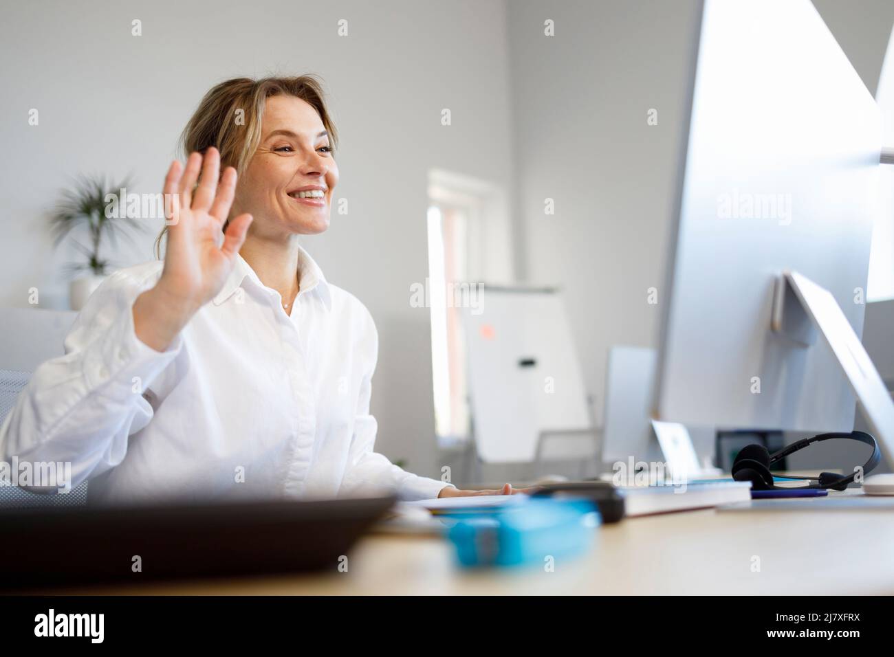 Smiling female entrepreneur waving hi-res stock photography and images ...