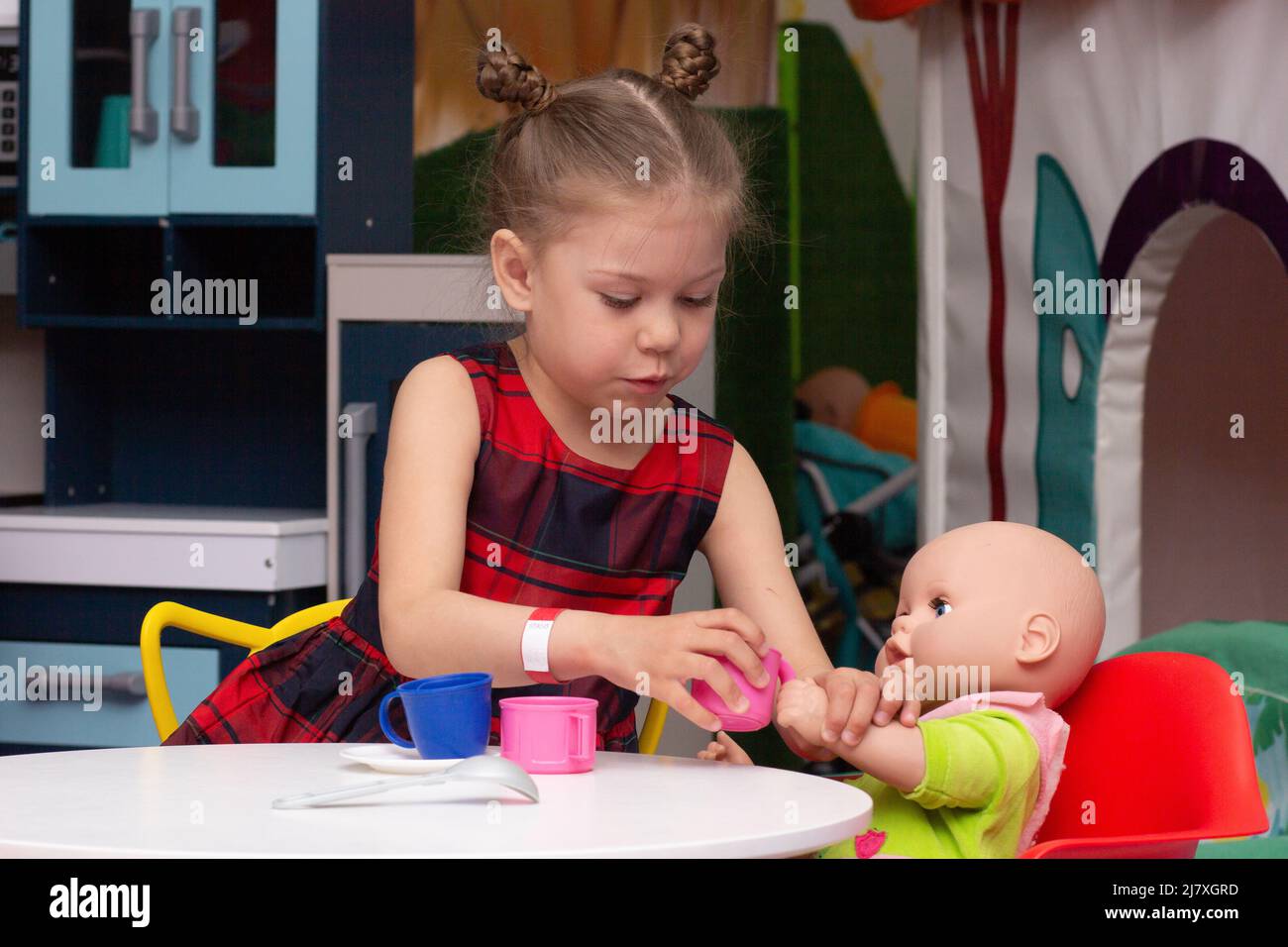 Happy and smiling child feeding tea doll Stock Photo - Alamy