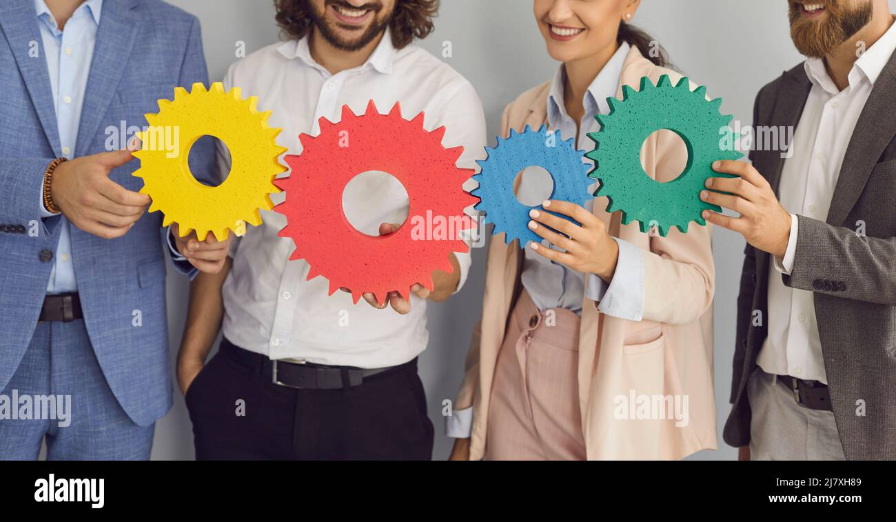 Team of people joining cogs to illustrate concept of teamwork and ...