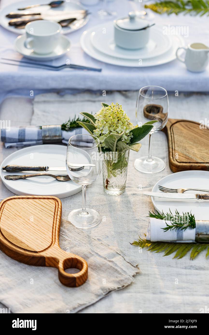 Summer holiday table set up. Elegant table setting with white dishes on ...