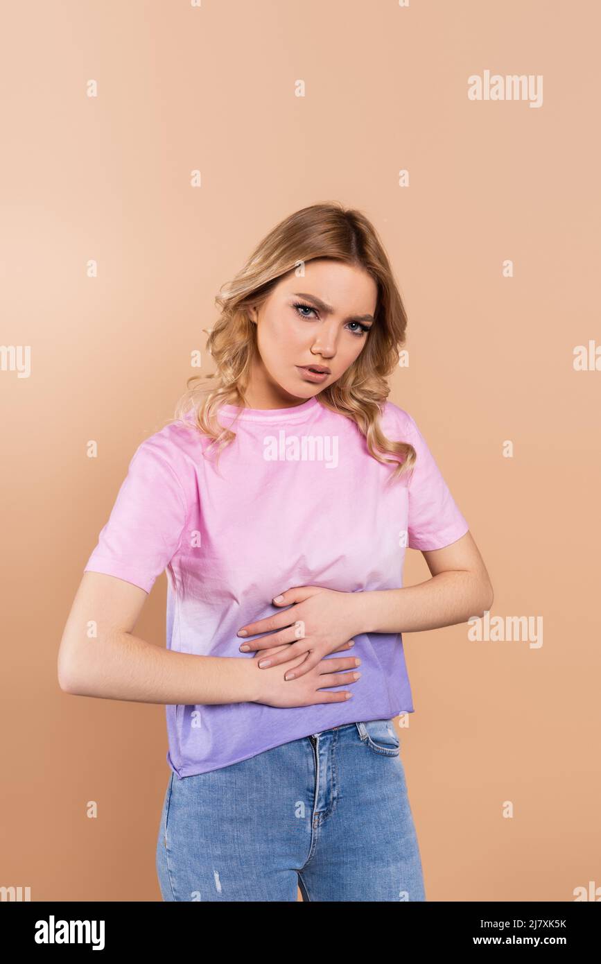 sad woman suffering from stomach ache and touching belly isolated on ...